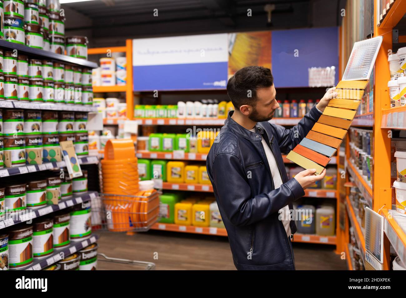 a buyer in a hardware store selects paint and varnish for renovation ...