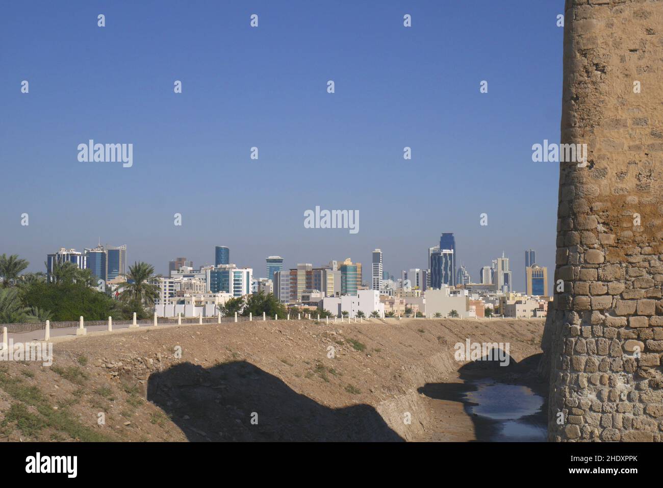 Fortified wall of the Bahrain Fort with the Seef district in the ...