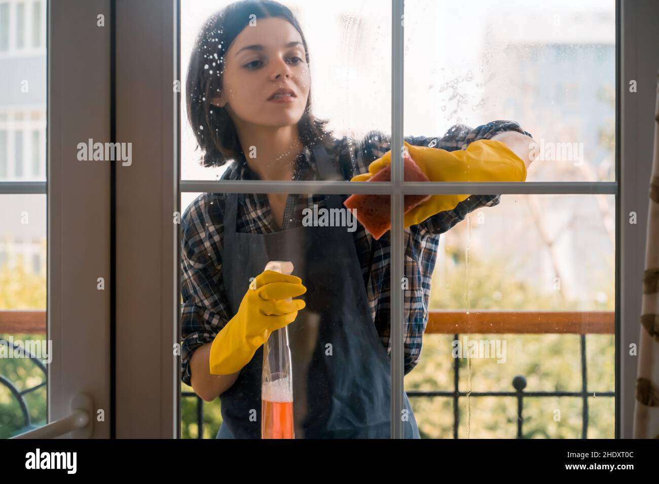 Woman washes the windows with a detergent Stock Photo - Alamy