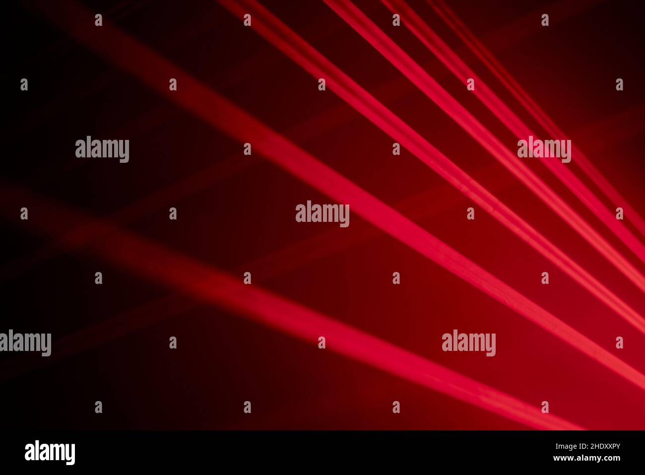Bright red neon laser lights illuminate the darkness creating lines and ...
