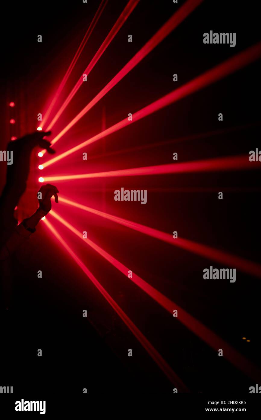 Bright red neon laser lights illuminate the darkness creating lines and ...