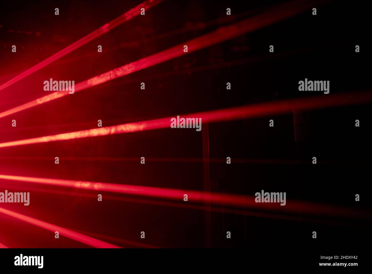 Bright red neon laser lights illuminate the darkness creating lines and ...