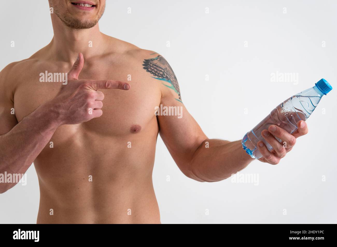 Male drink-water fitness is pumped with a towel on a white background ...