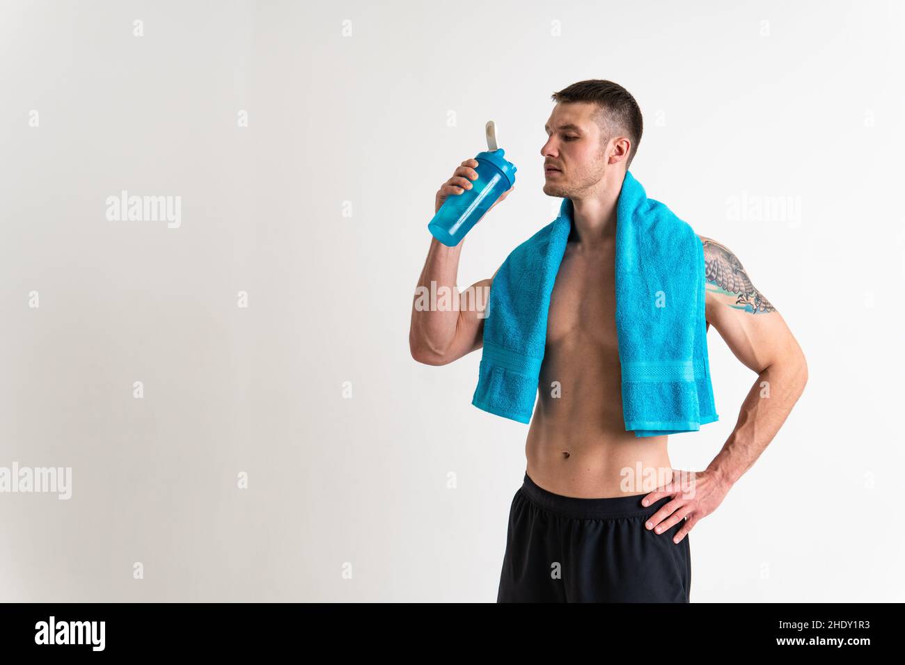 Male drink-water fitness is pumped with a towel on a white background ...