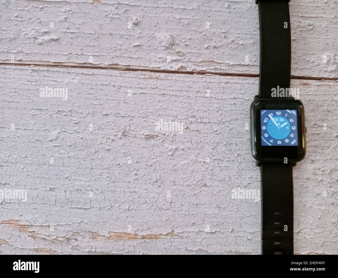 A smart watch in a wooden surface. Watch placed in the right side of ...