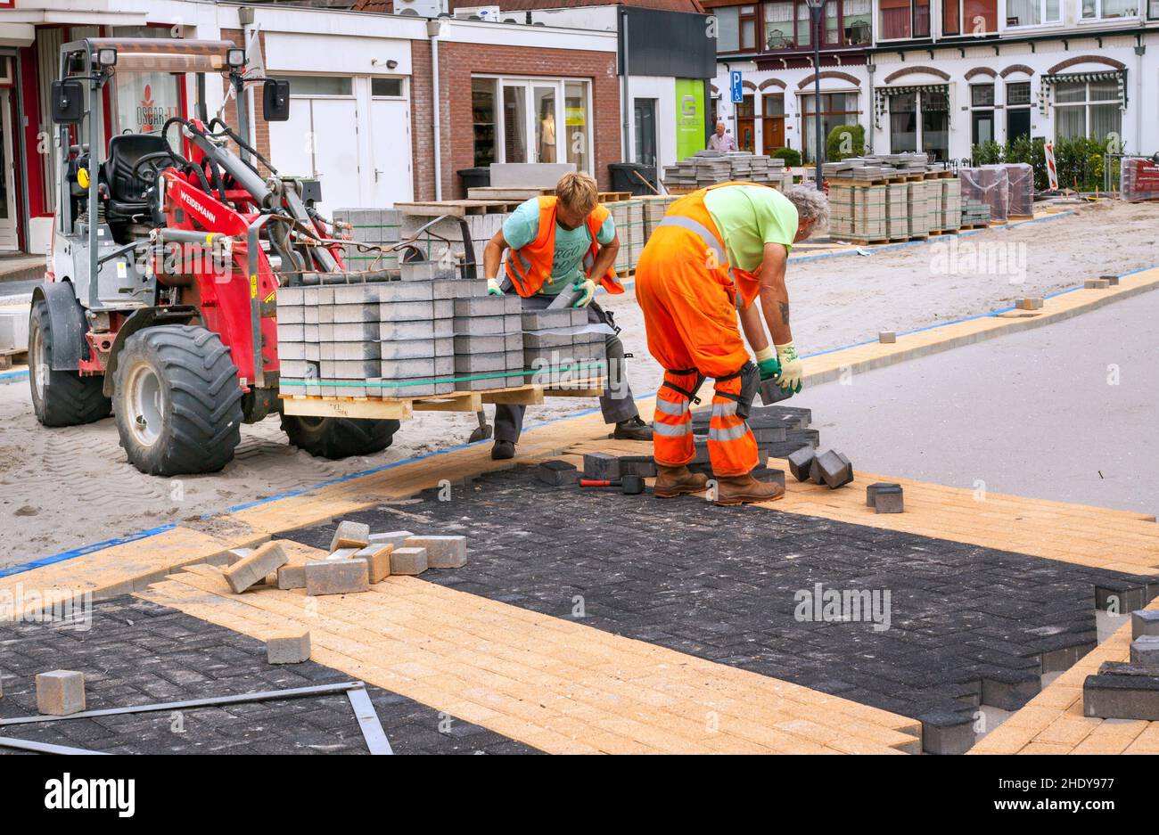 Bricklayers laying new pavement Stock Photo - Alamy