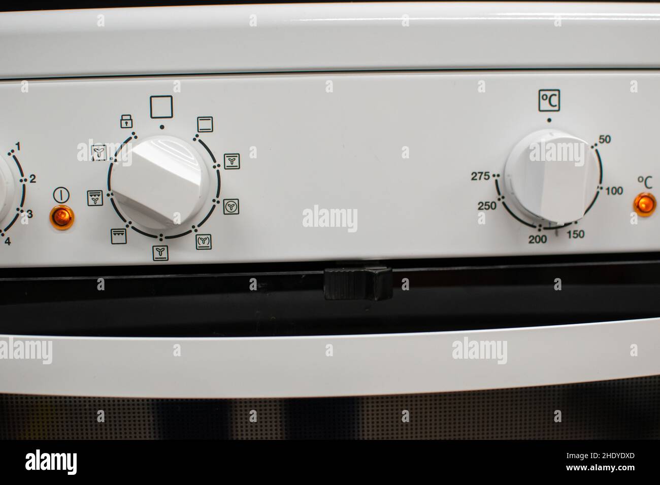 Close-up shot of a white electric cooker's front panel with multiple ...