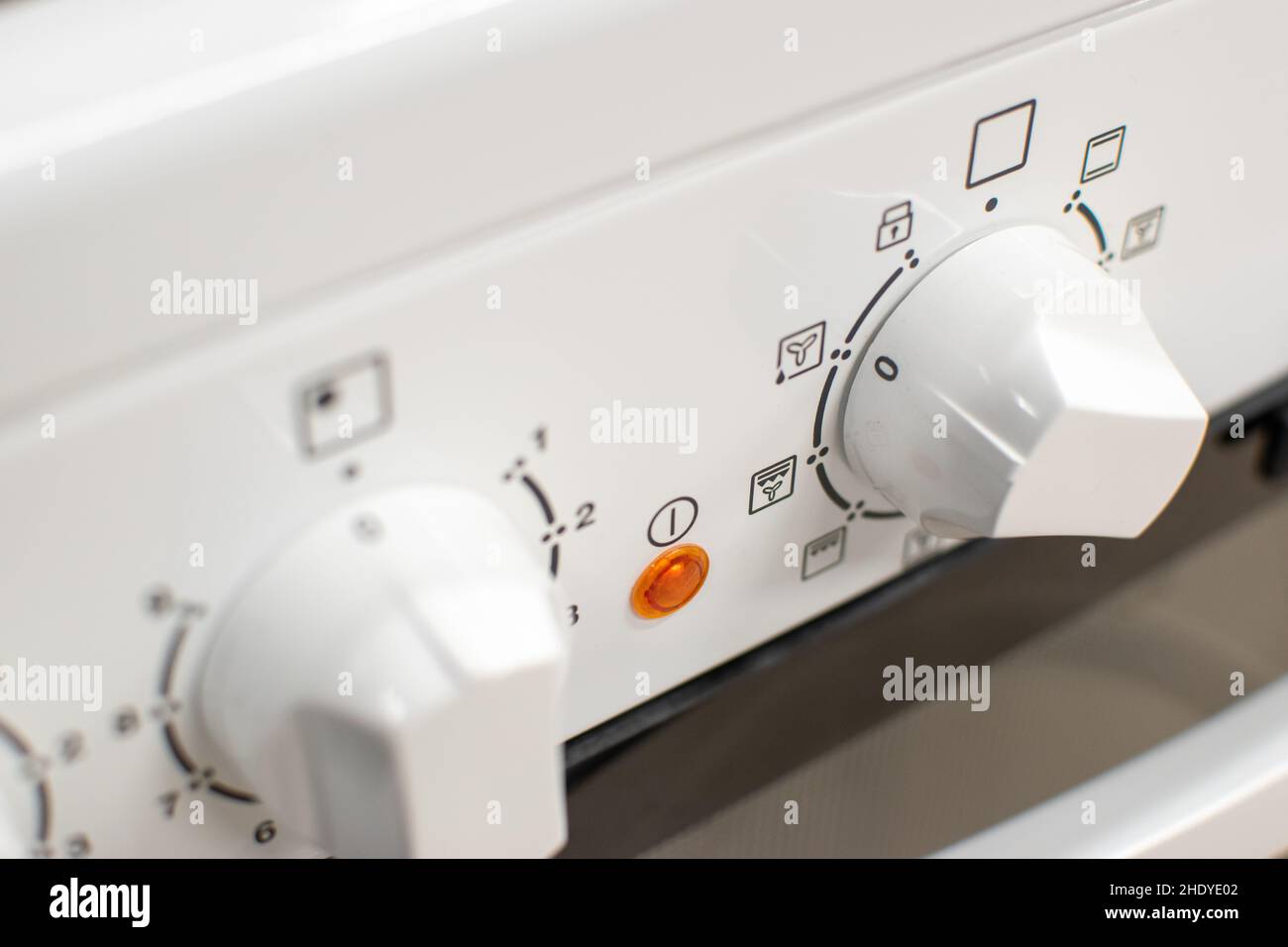 Close-up shot of a white electric cooker's front panel with multiple ...