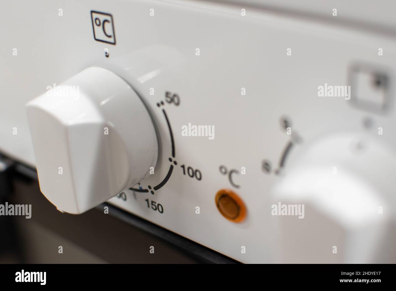 Close-up shot of a white electric cooker's front panel with multiple ...