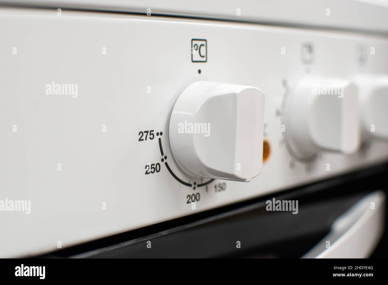 Close-up shot of a white electric cooker's front panel with multiple ...