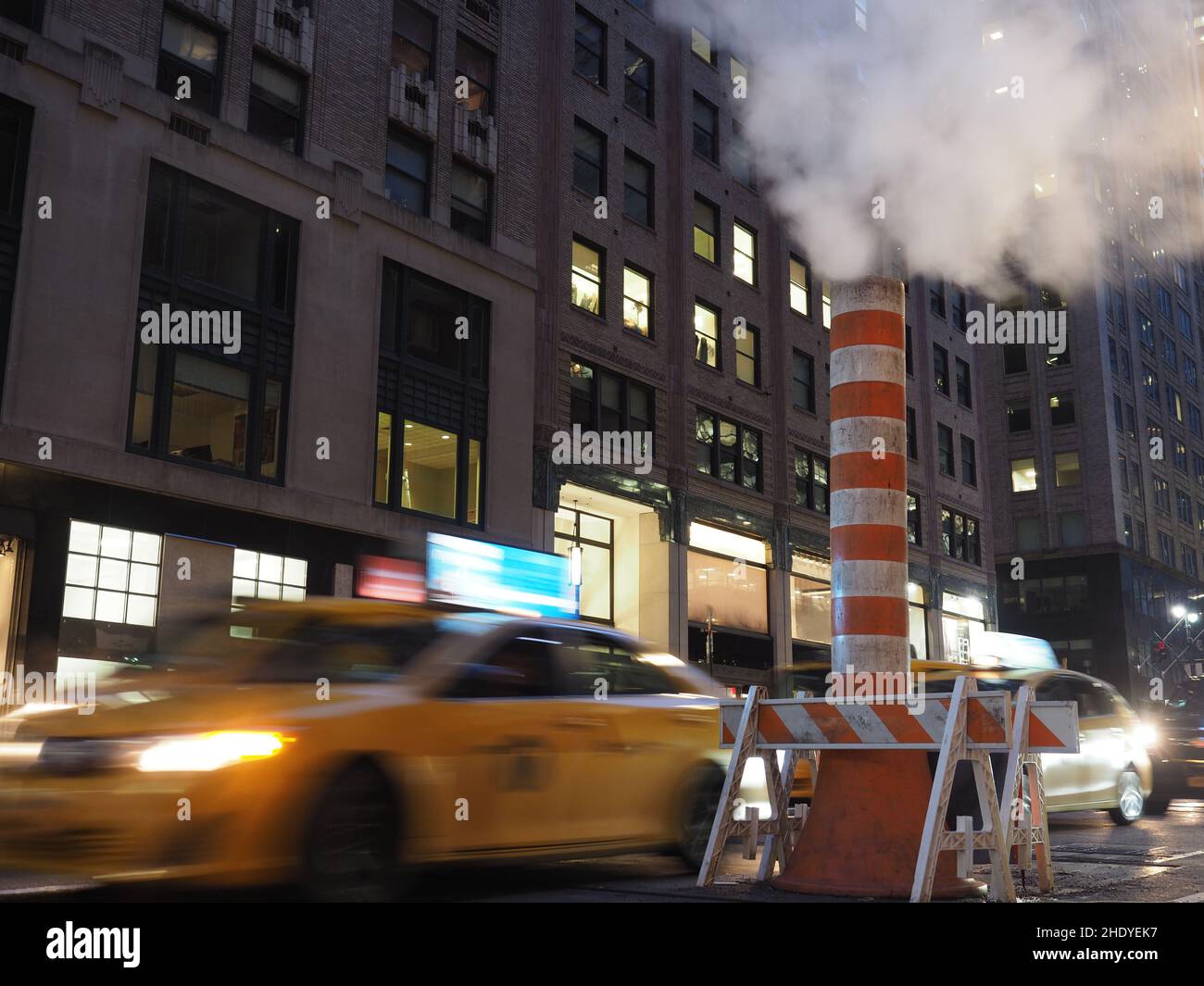 Long exposure image of a cab passing by a steam stack in Manhattan ...