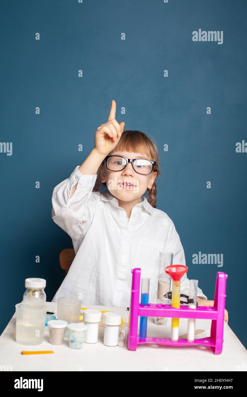 Shocked child girl student doing science experiments and pointing up on ...