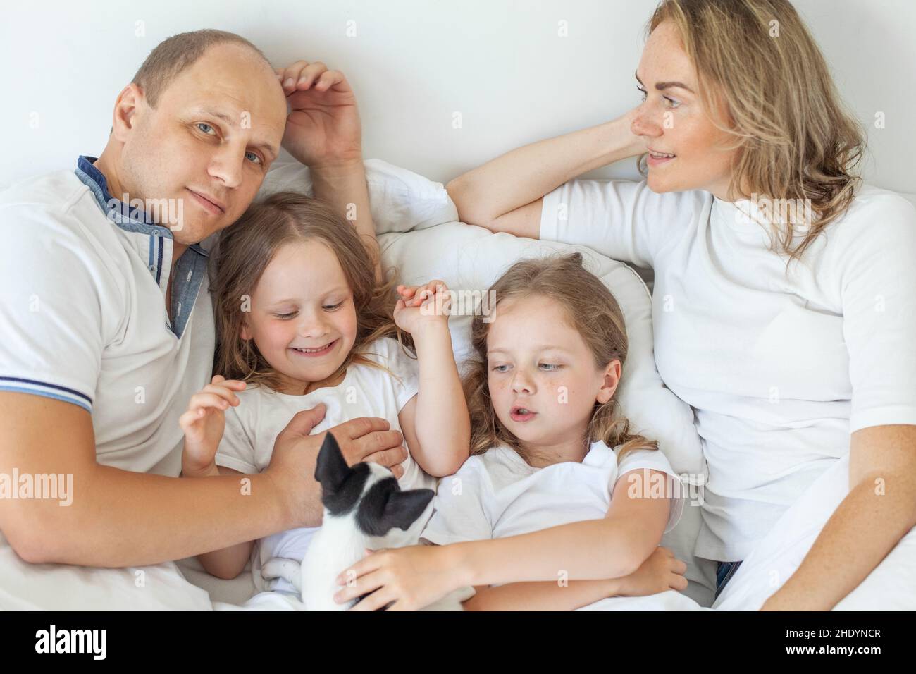 Happy family lying down on bed at home Stock Photo - Alamy