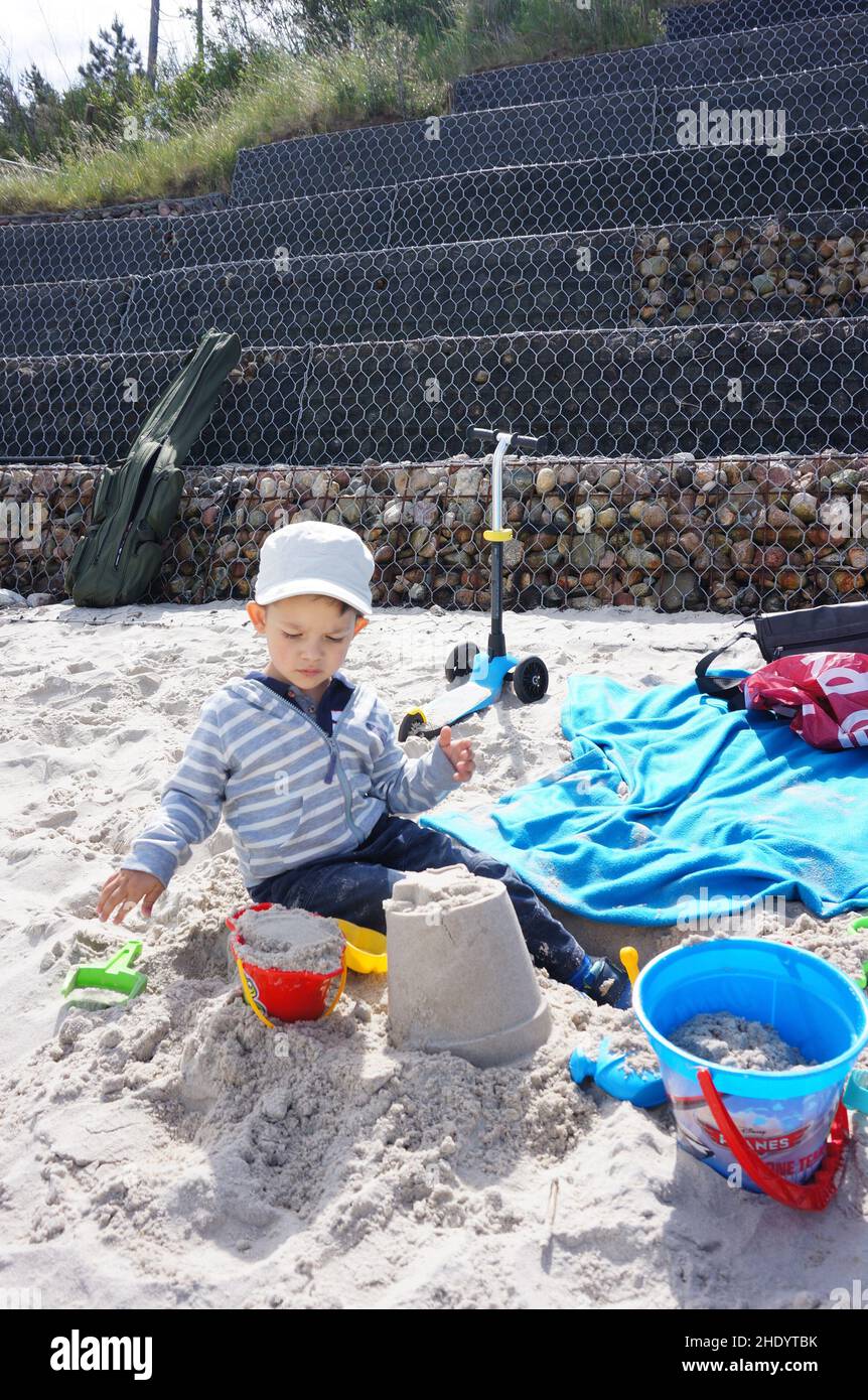 Boy playing on beach sand Stock Photo - Alamy