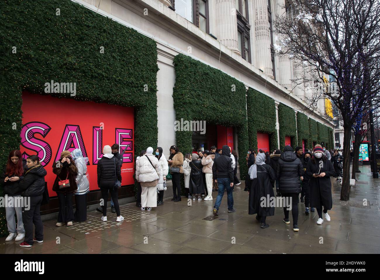 People queue in front of a Sale logo outside Selfridges department ...