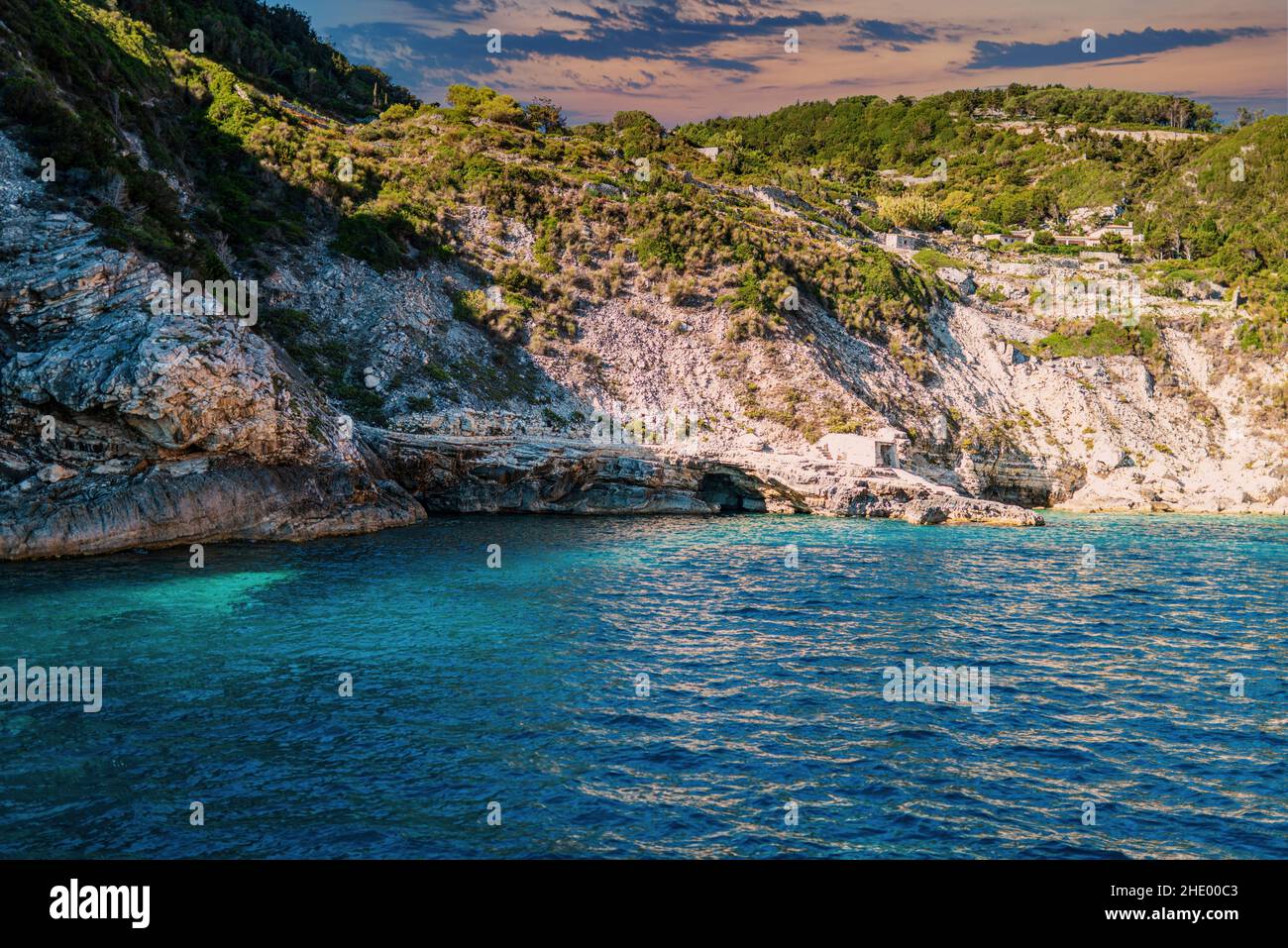 Green forest-covered high rocky steep cliffs on shore of Grecian Corfu ...