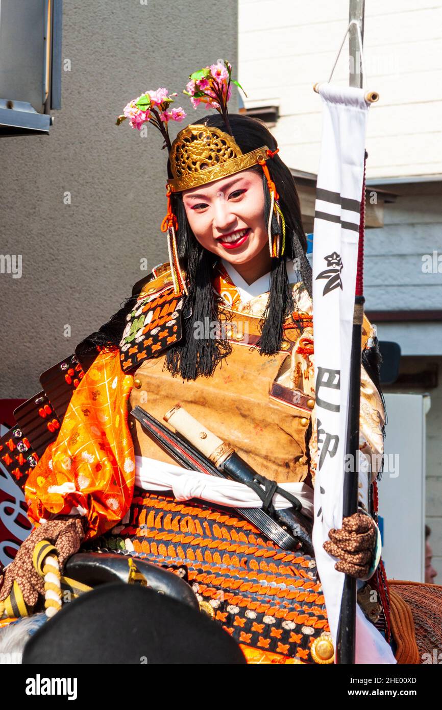 Close up of a smiling Japanese young woman, mounted on horse, dressed ...