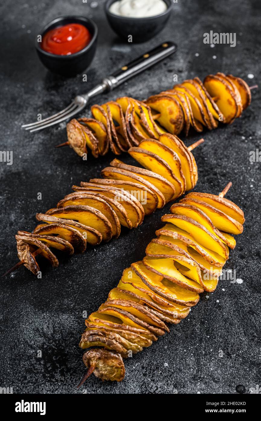 Roasted Tornado or twisted potatoes with ketchup sauce. Black ...