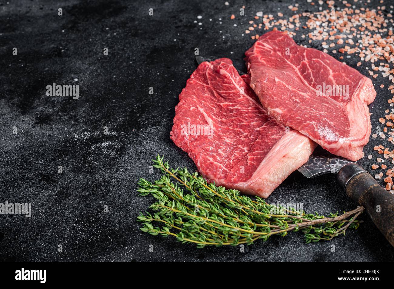Butcher choise beef raw steaks on butcher knife. Black background. Top ...