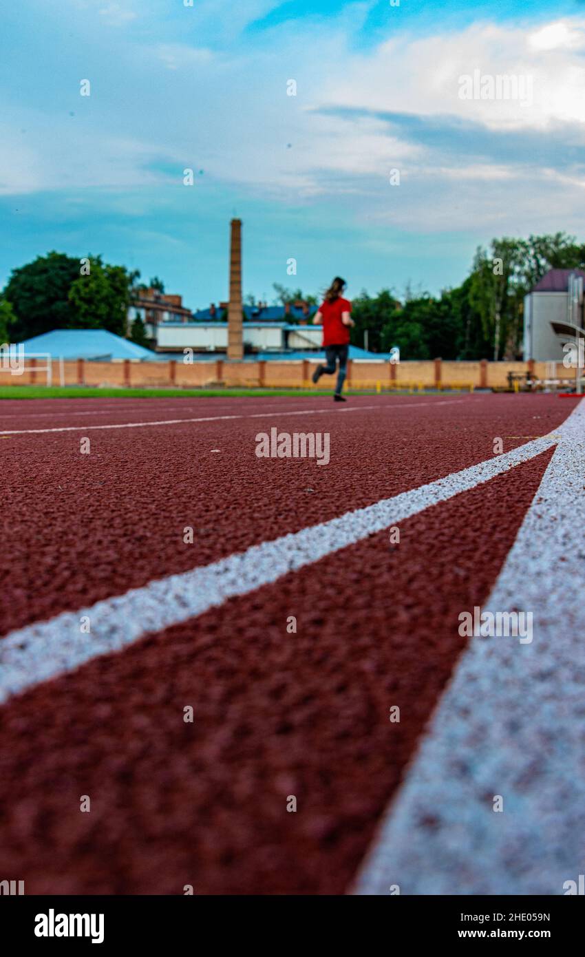 Selective focus of red-painted track and field with white lines Stock ...