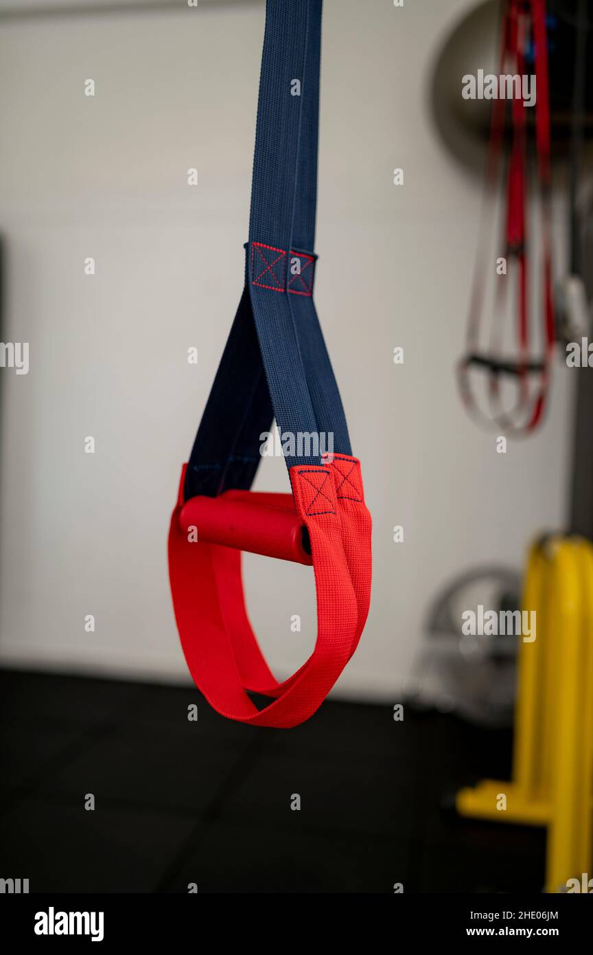 Vertical of two training slings hanging on a gym on a blurry background ...