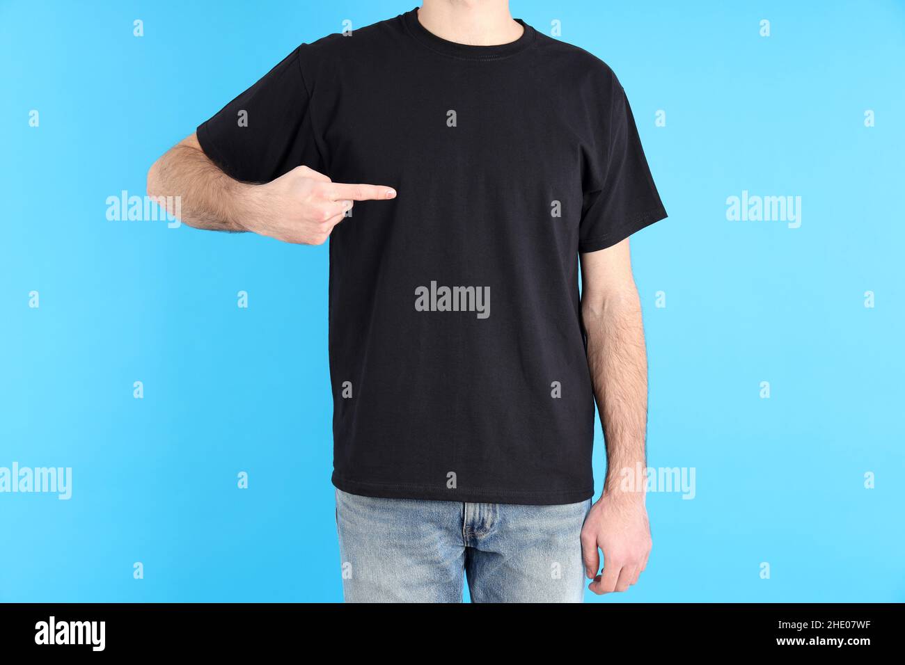 Man in blank black t-shirt on blue background Stock Photo - Alamy