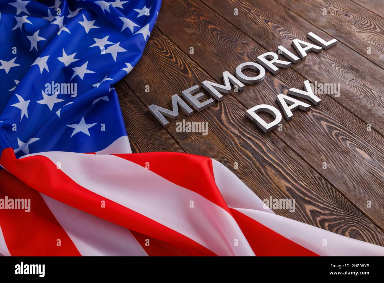 the words memorial day laid with silver metal letters on wooden board ...