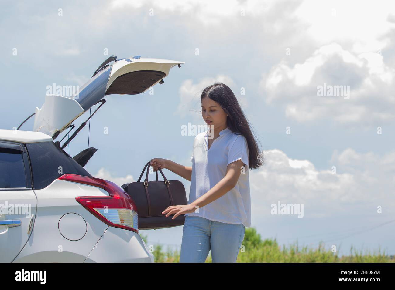 Family of four loading boot of car with luggage hi-res stock ...