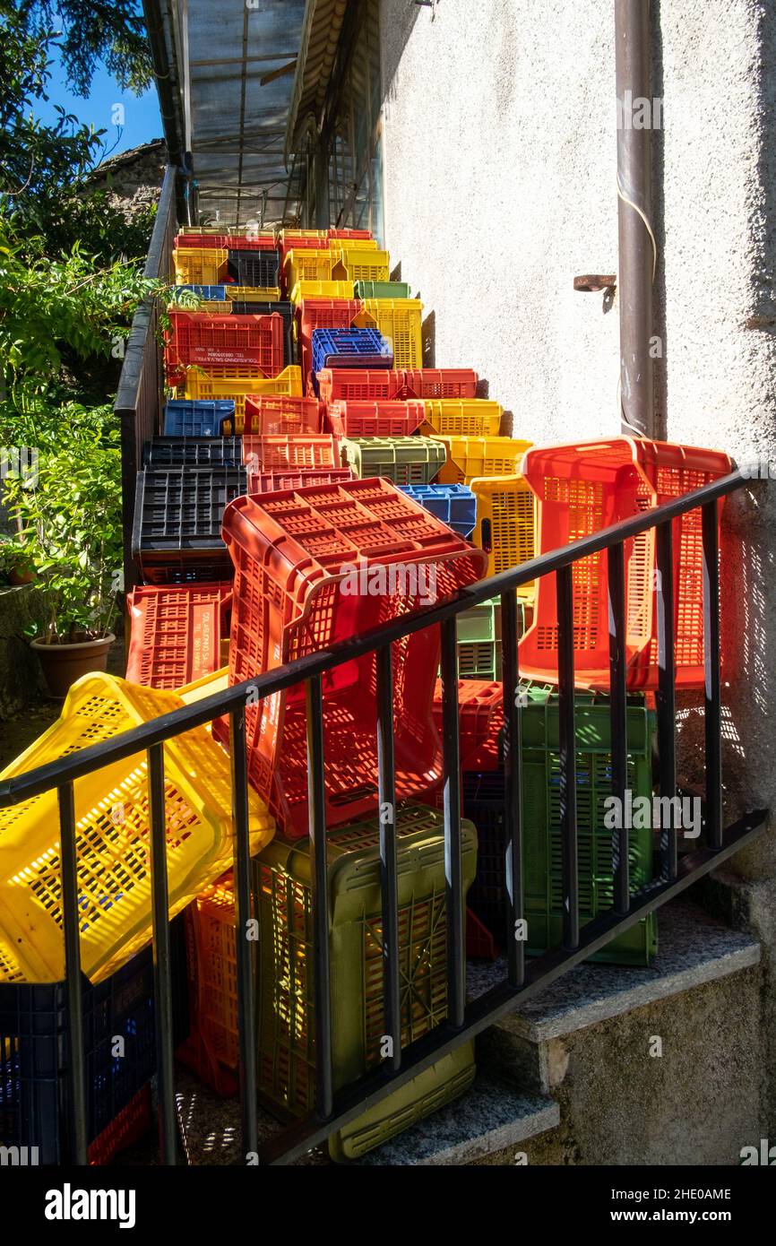 colored plastic crates, stacked on a staircase in a rural village in ...