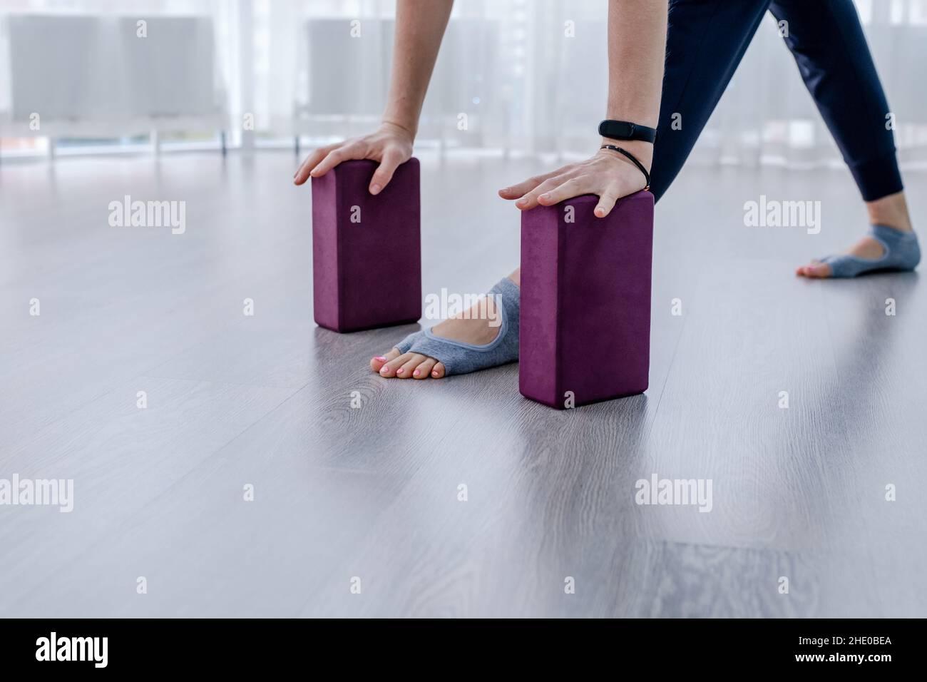 Close-up a woman leans her palms on purple yoga blocks Stock Photo - Alamy