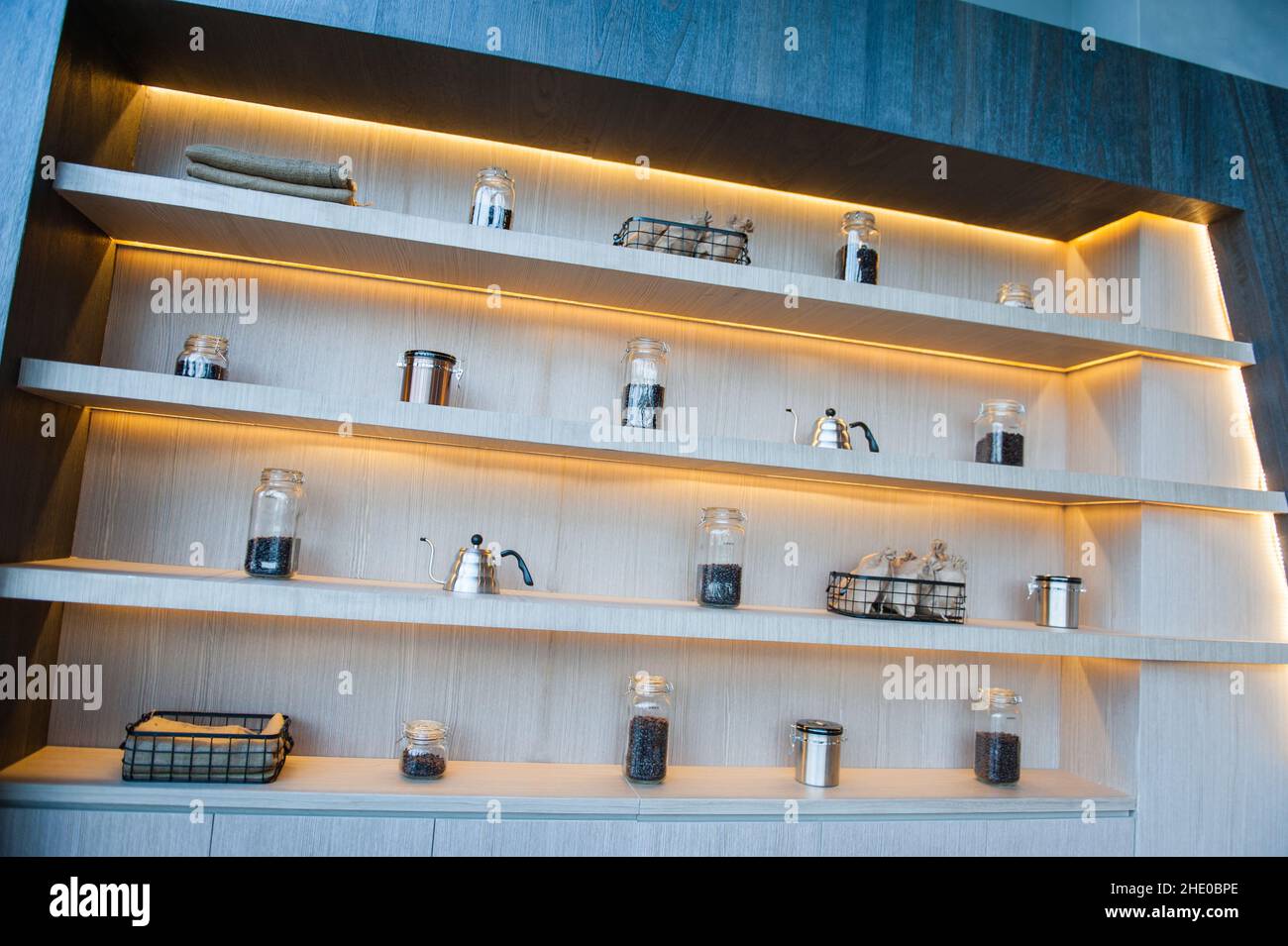 Wooden shelf with kettles and jars of coffee beans Stock Photo - Alamy