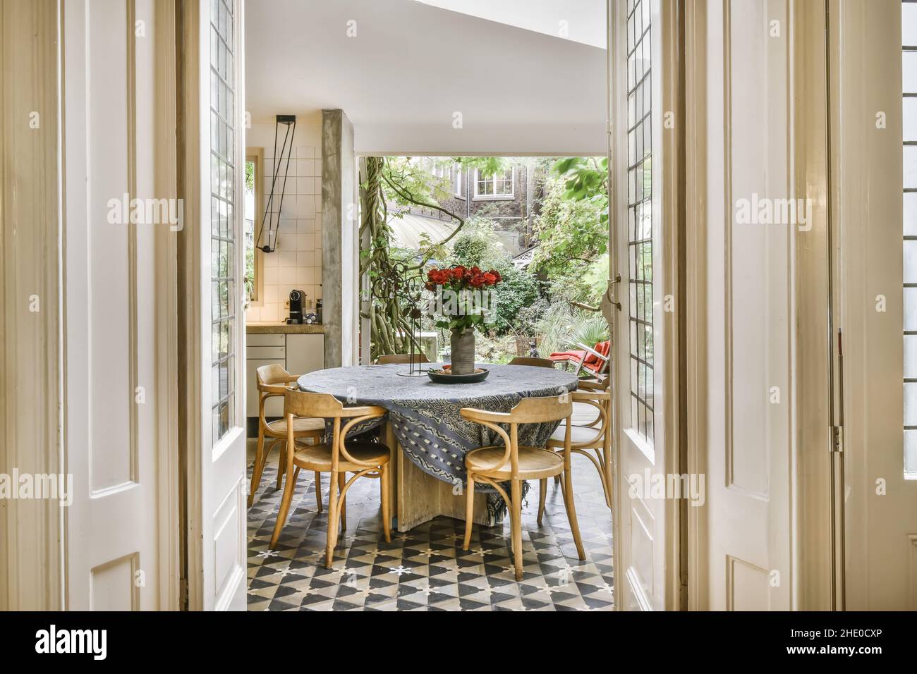 Chic dining room with round table with tablecloth and wooden chairs and ...