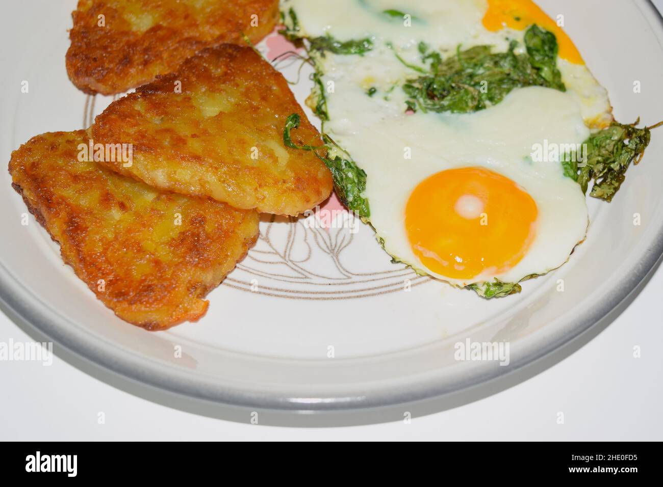 Fried eggs with spinach and hash browns Stock Photo - Alamy