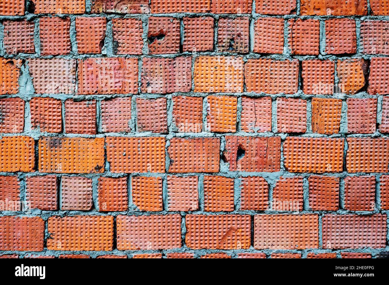 An old authentic brick wall with antique brickwork. Uneven defective ...