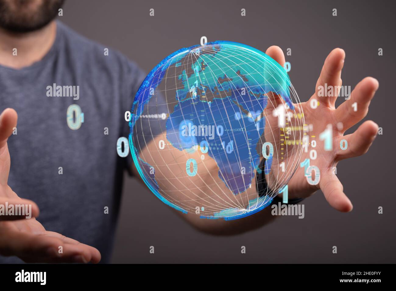 Businessman holding a floating render of a globe with binary code- global network concept Stock ...