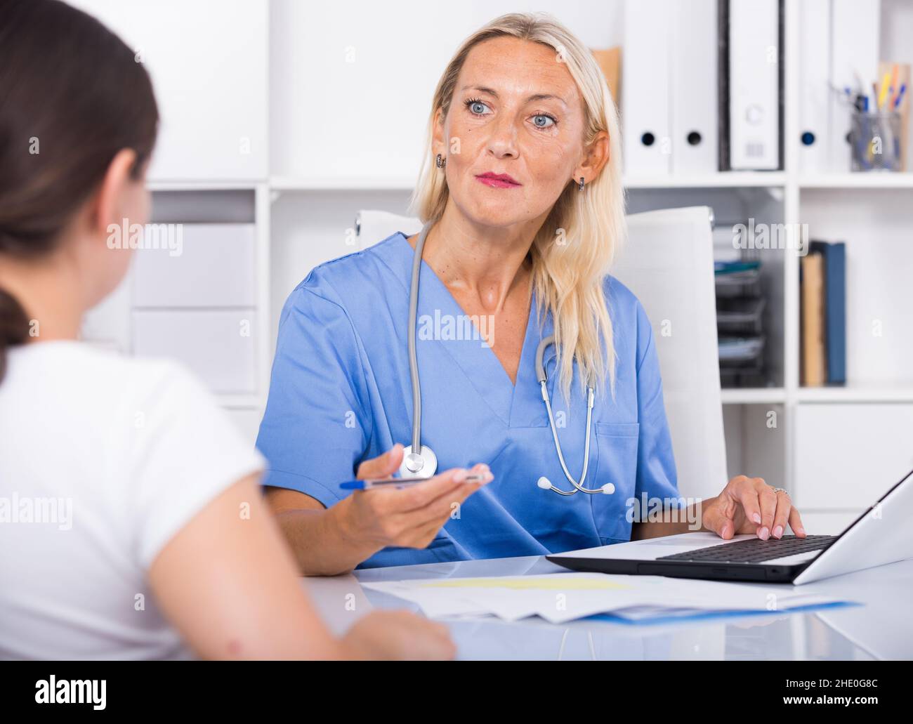 Female doctor listening to patient complaints Stock Photo - Alamy