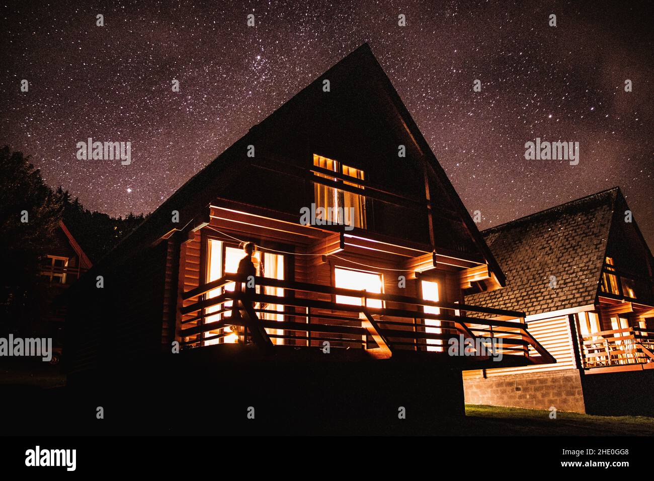 Mesmerizing view of lady in her house's balcony at night with a sky ...