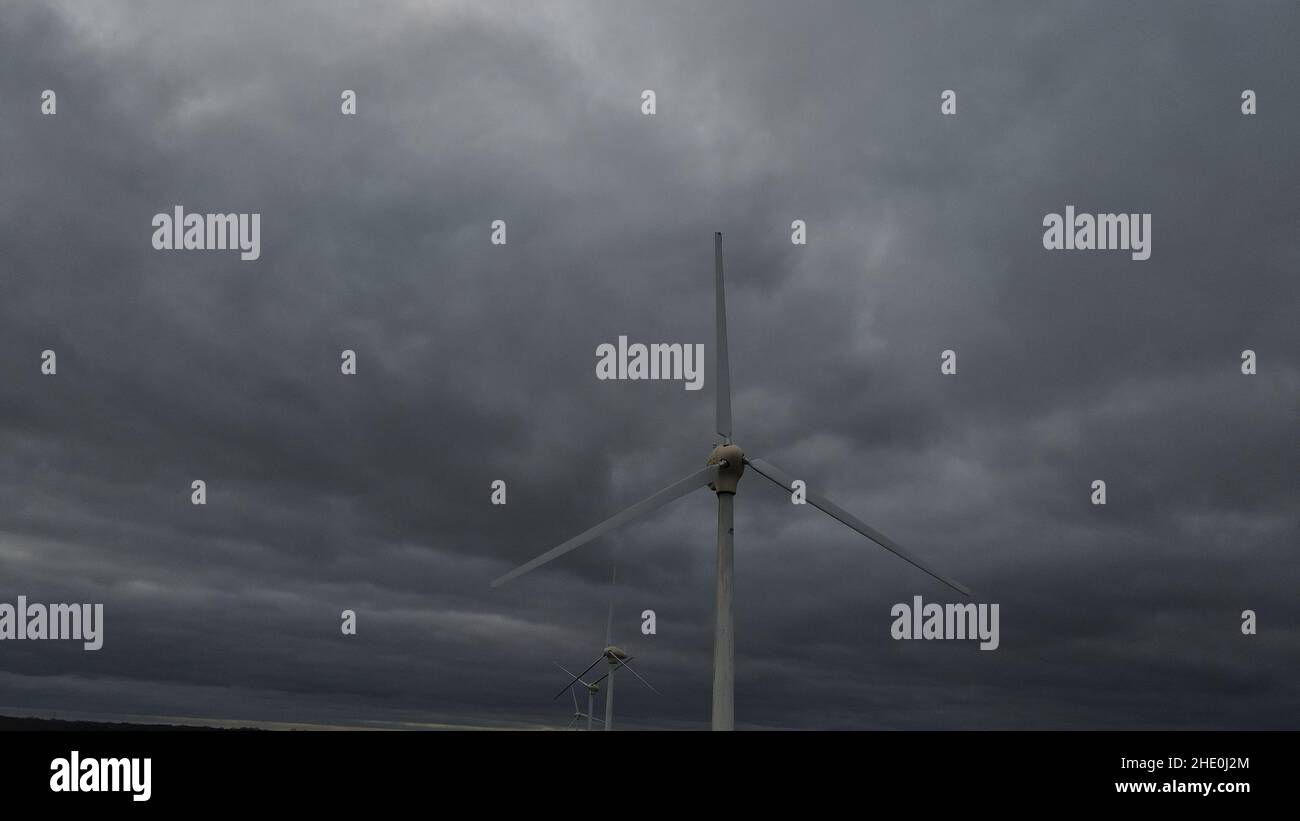 Wind turbine with dark clouds in background Stock Photo - Alamy
