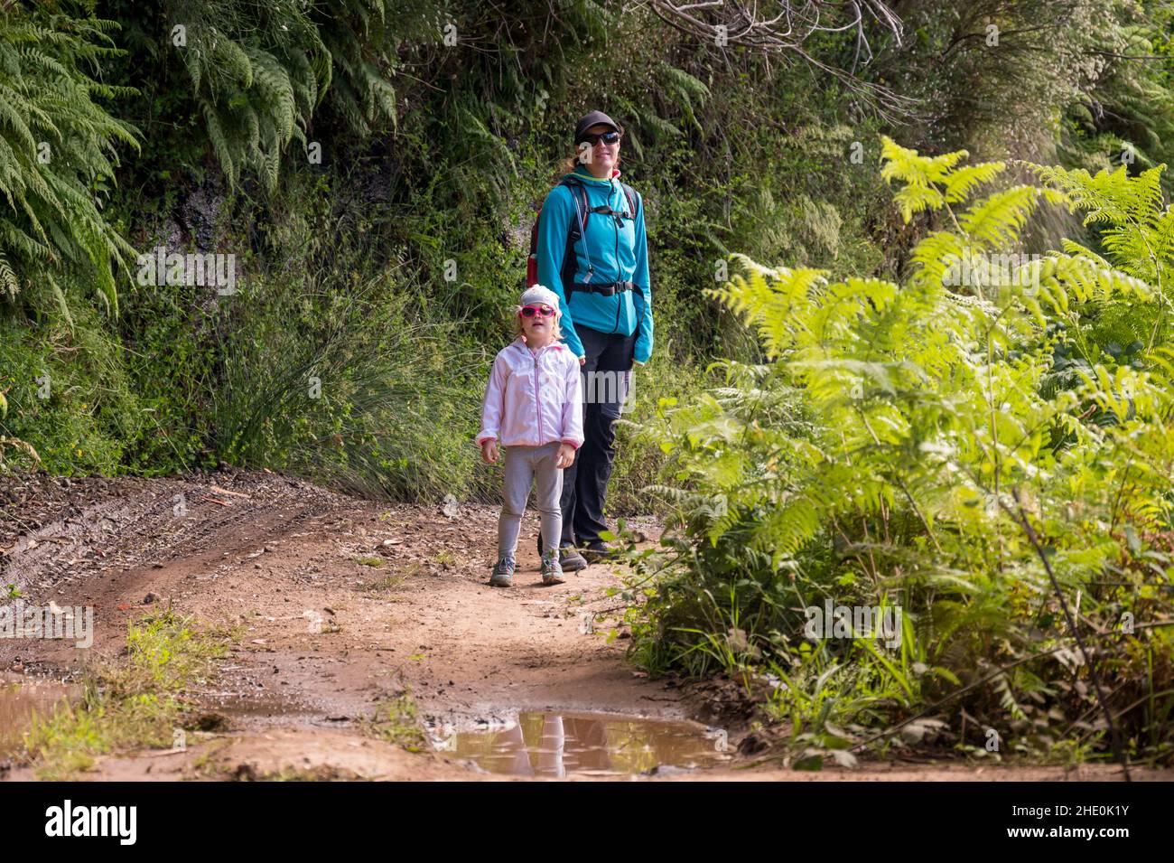 Mother and daughter walking along forest path Stock Photo - Alamy