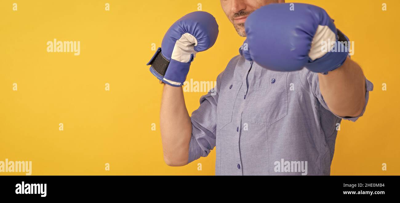 man punching in boxing gloves on yellow background, copy space, success ...