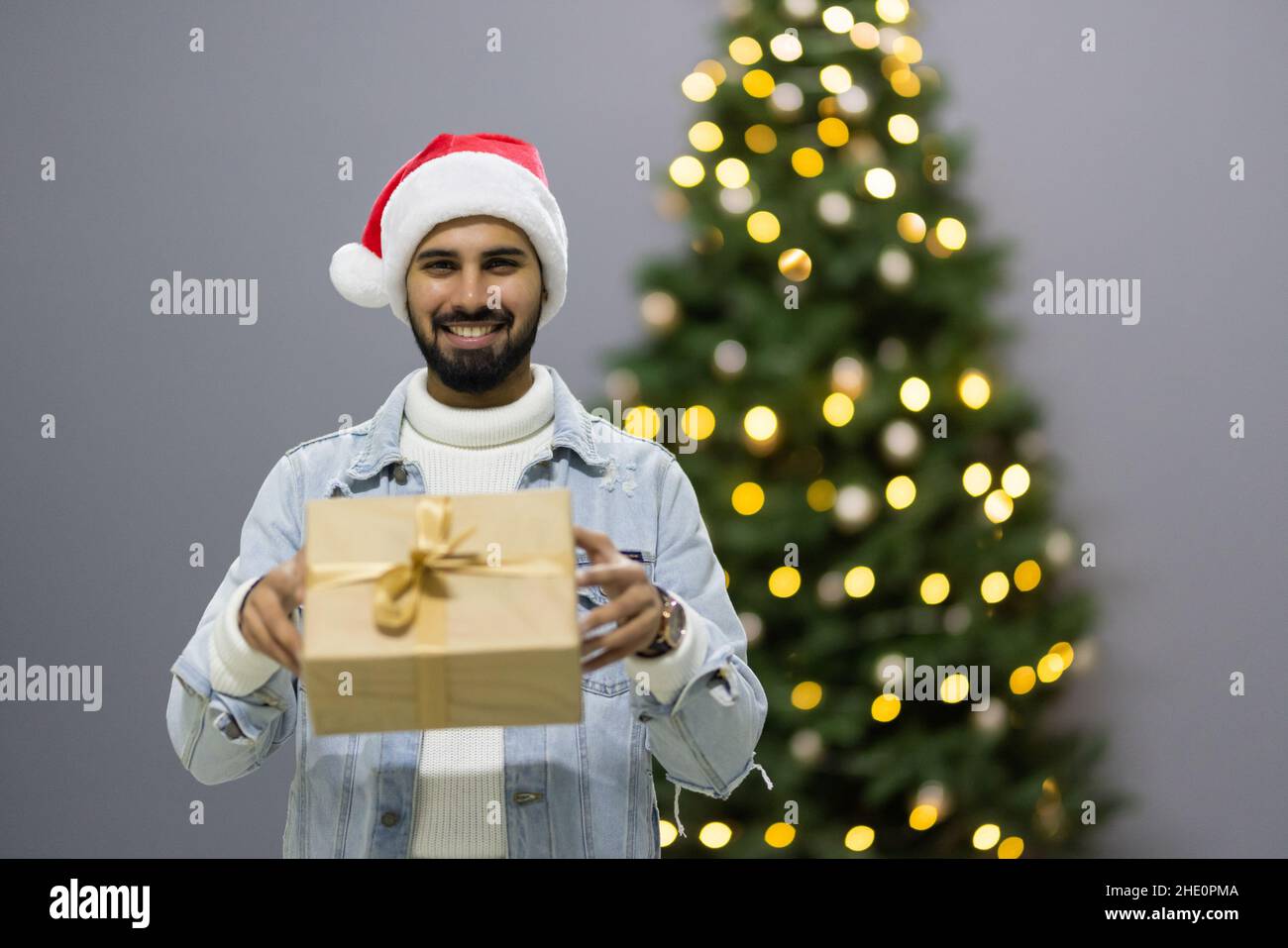 Curious Santa man sitting in front of Christmas tree background Stock ...
