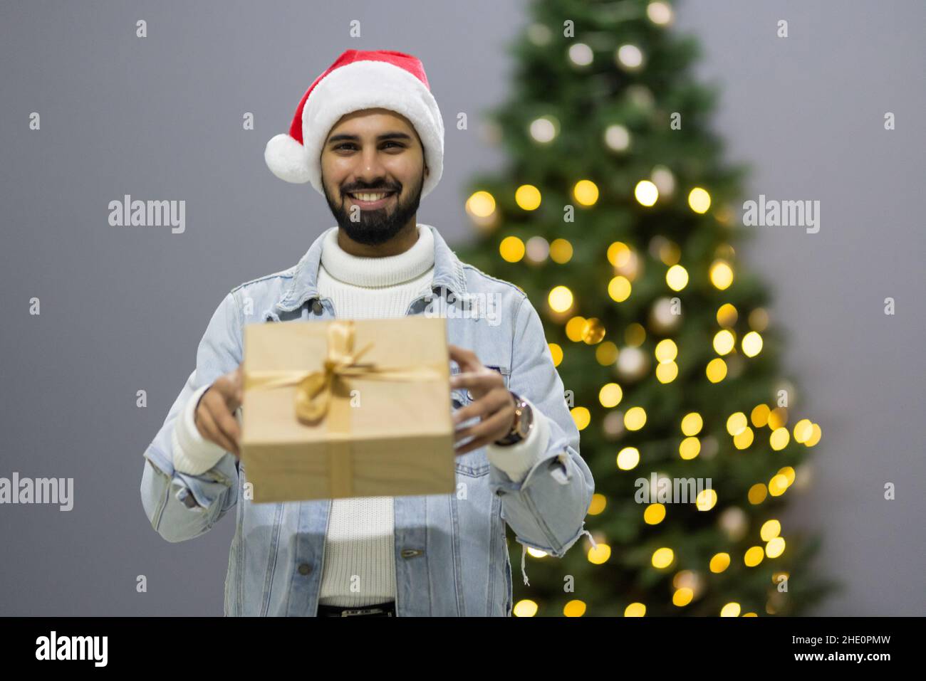 Curious Santa man sitting in front of Christmas tree background ...