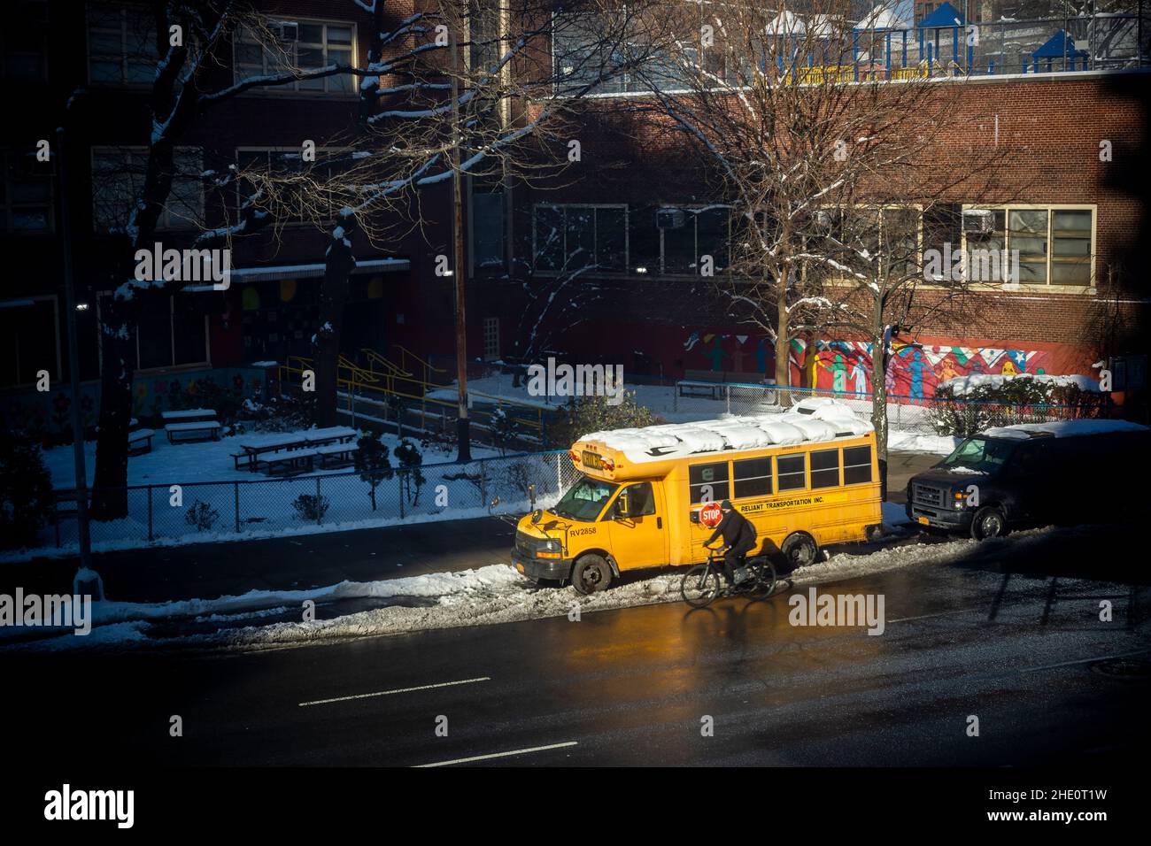 A snow-covered school bus parked in front of PS33 in Chelsea in New ...