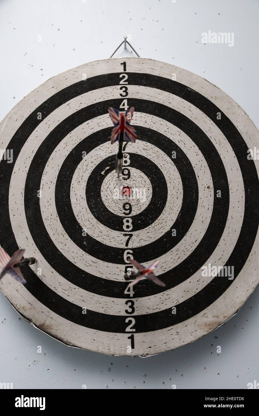 game details target shooting hanging on a wall with darts in the center ...