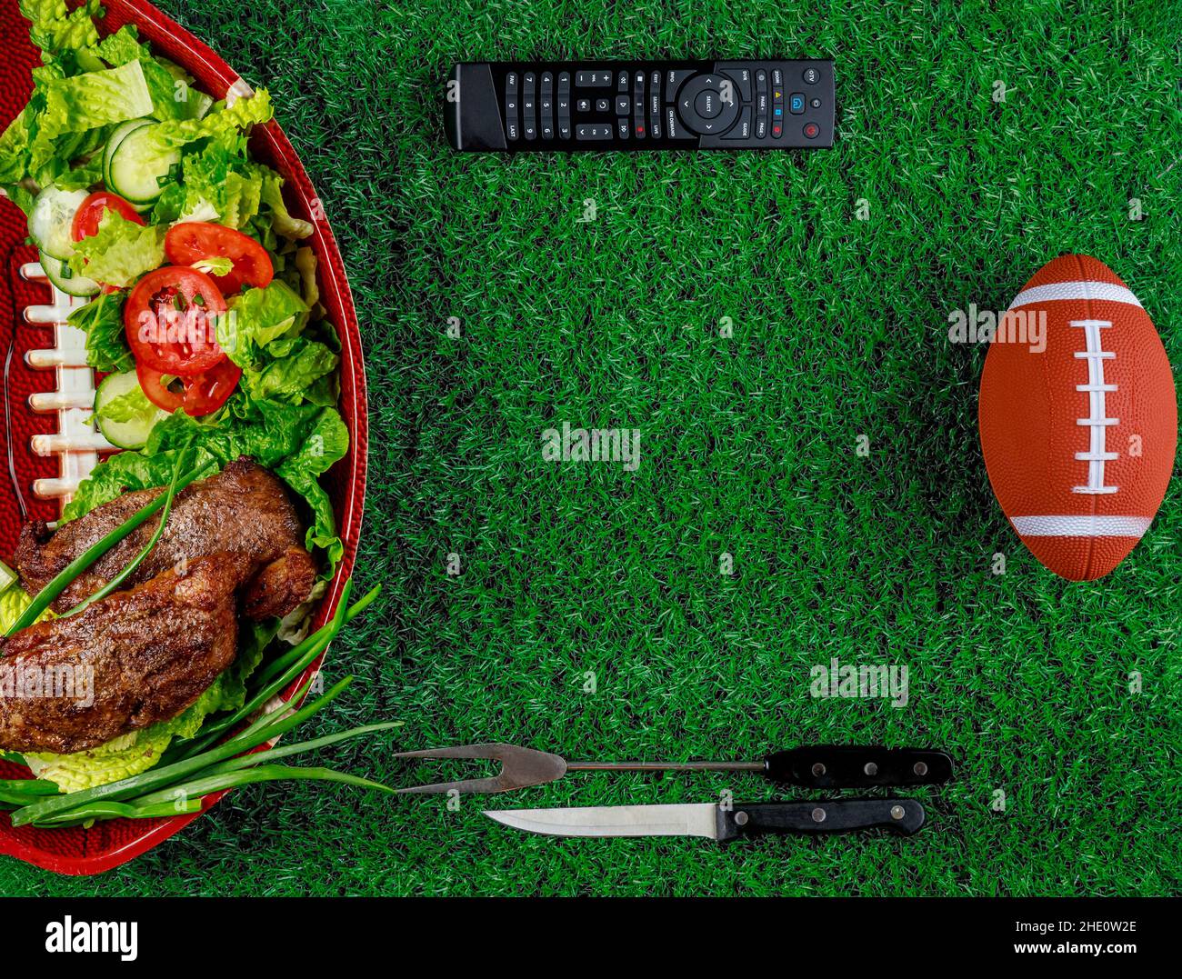 Tasty food on the plate with tv remote controller for the football ...