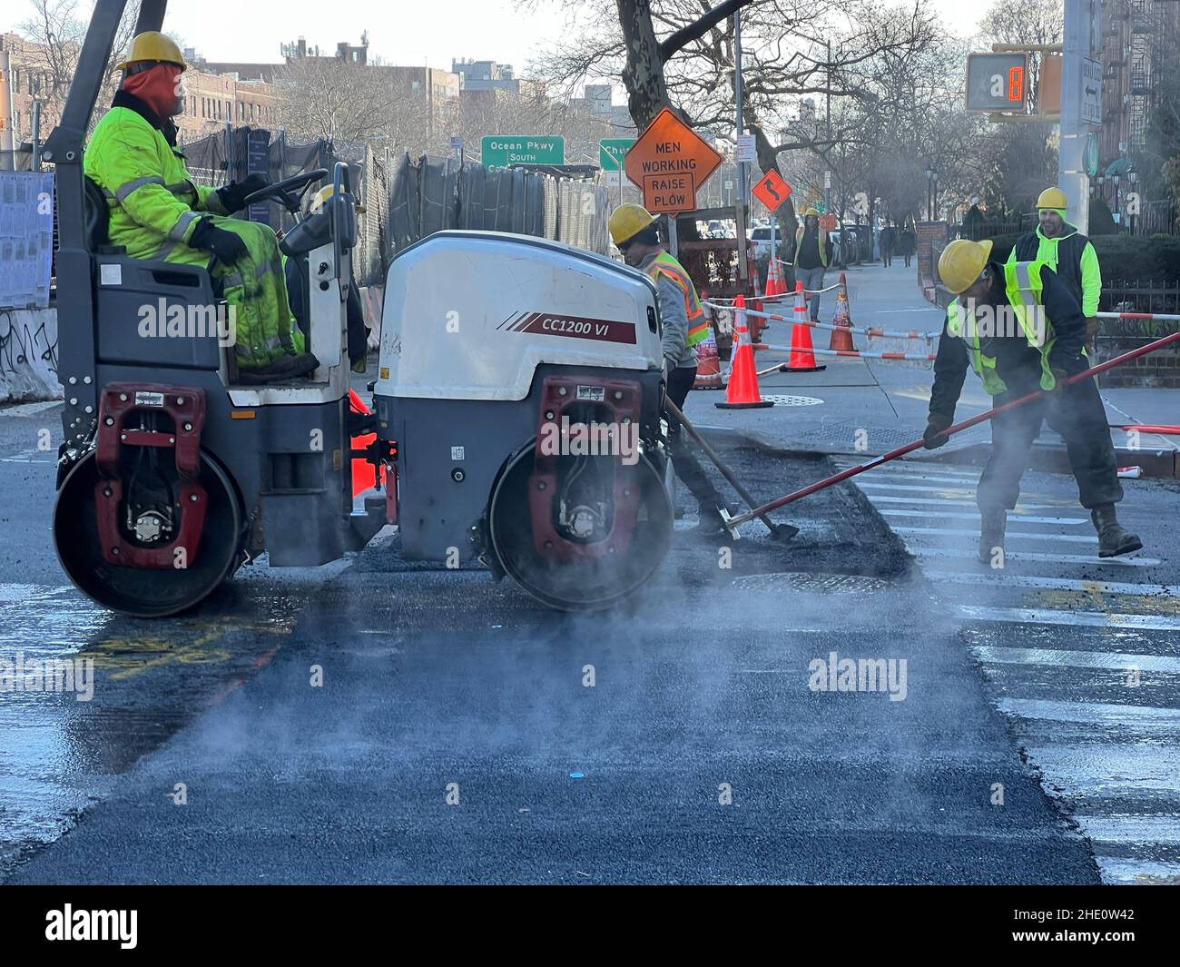 City workers tar the street surface after completed underground pipe ...