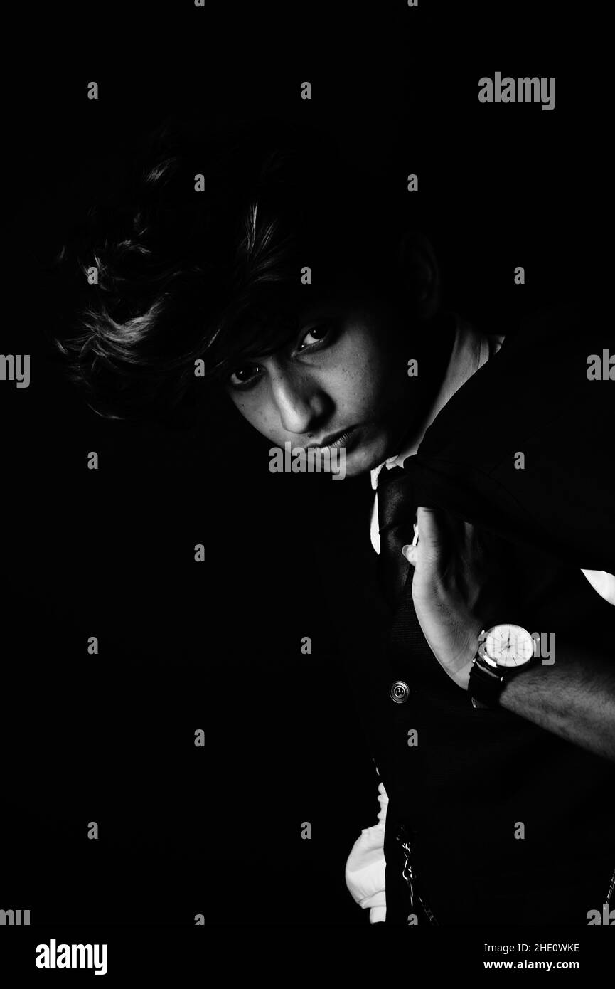 Grayscale shot of an enigmatic man posing in classic clothes and ...