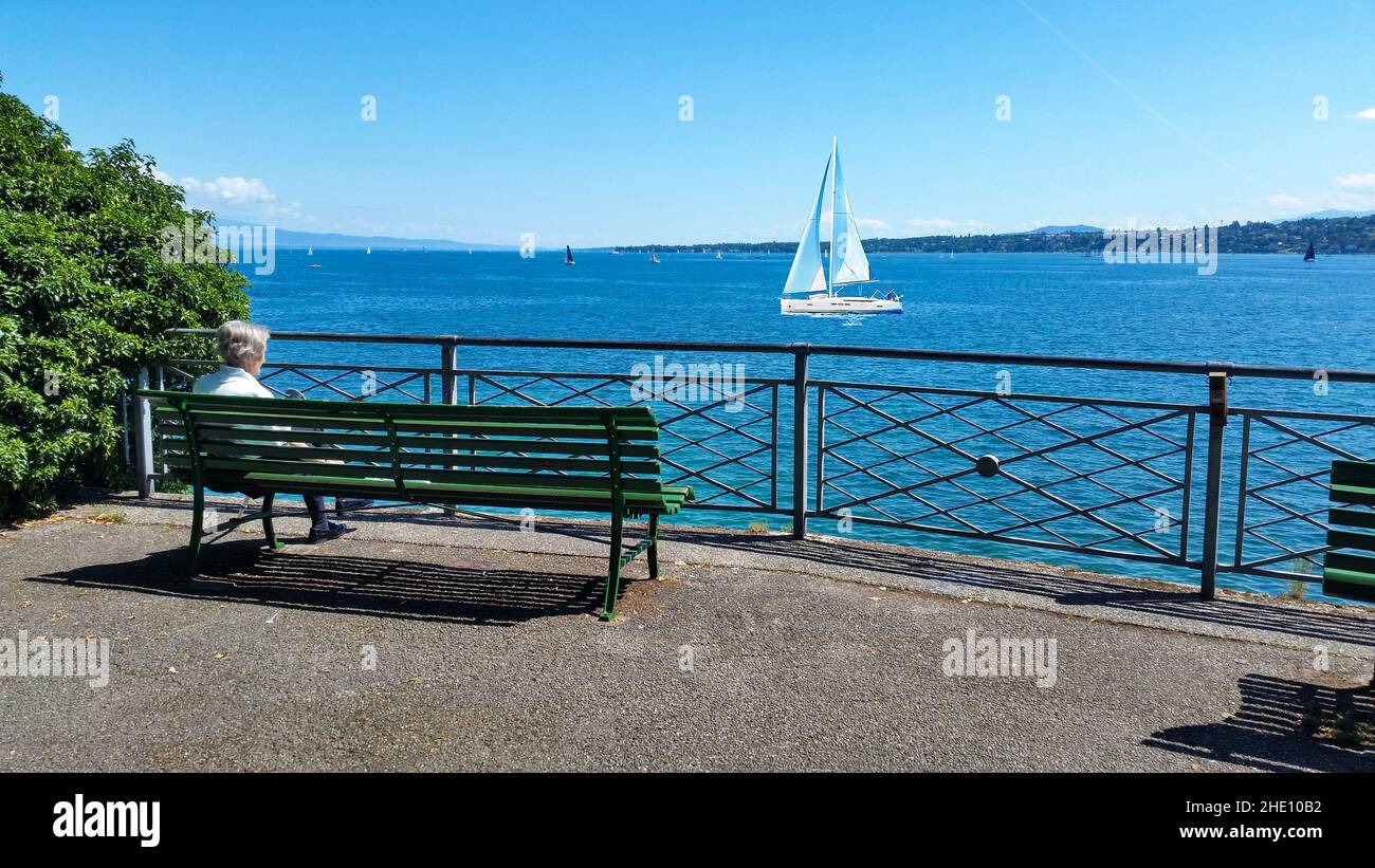 An old lady is watching the yacht in peaceful lake view in Geneva Stock ...