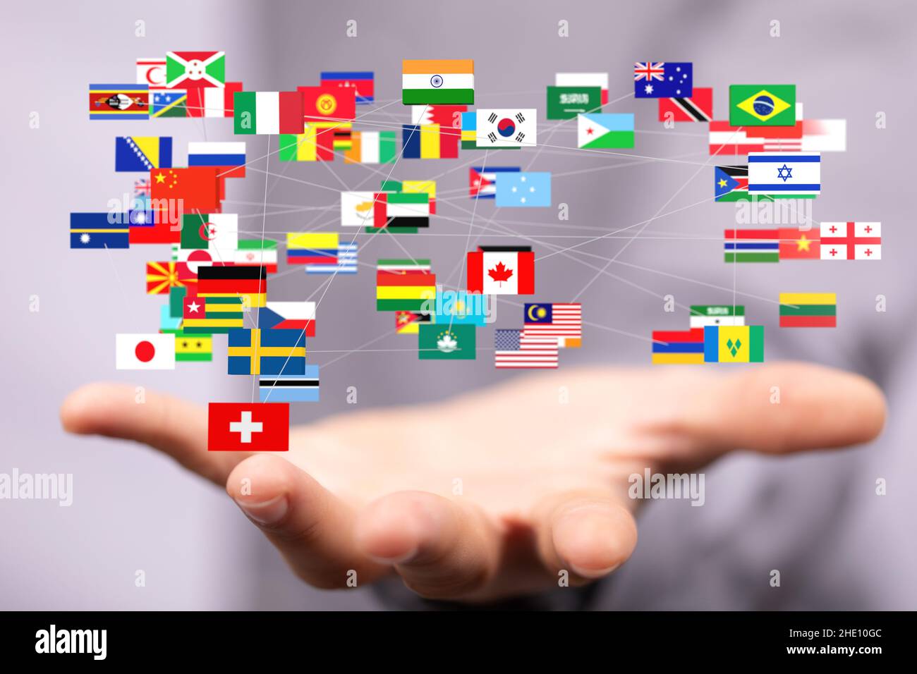 Male's hand holding a bunch of illustrated flags of different countries ...
