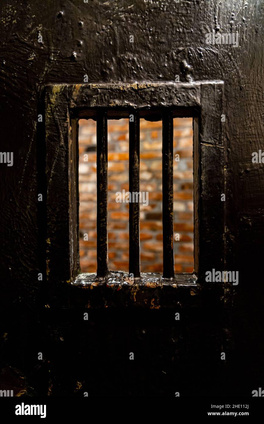 Old huge dark steel doors of cell with red brick wall behind Stock ...